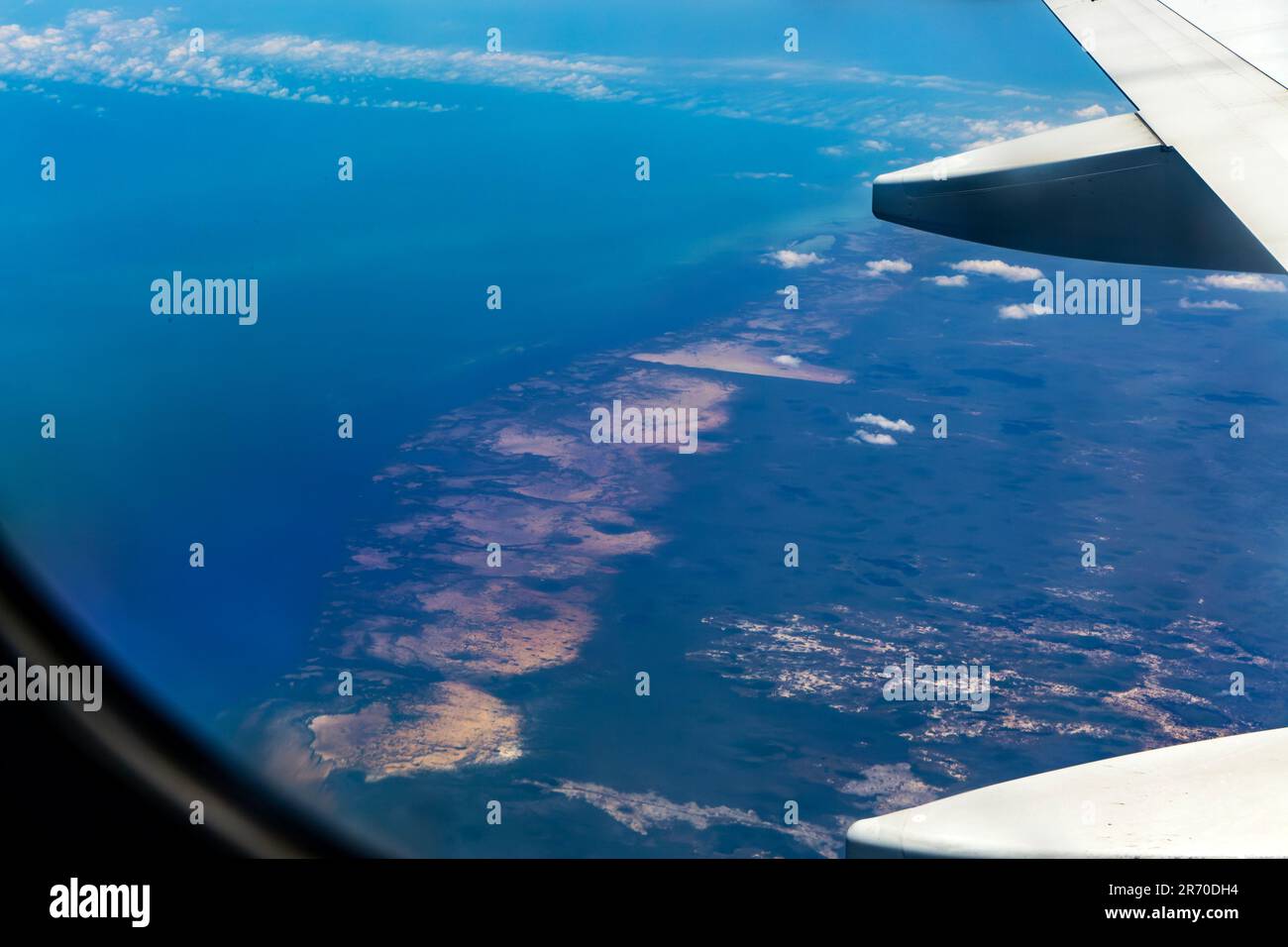 Oblique angle aerial view through plane window over Gulf of Mexico ...