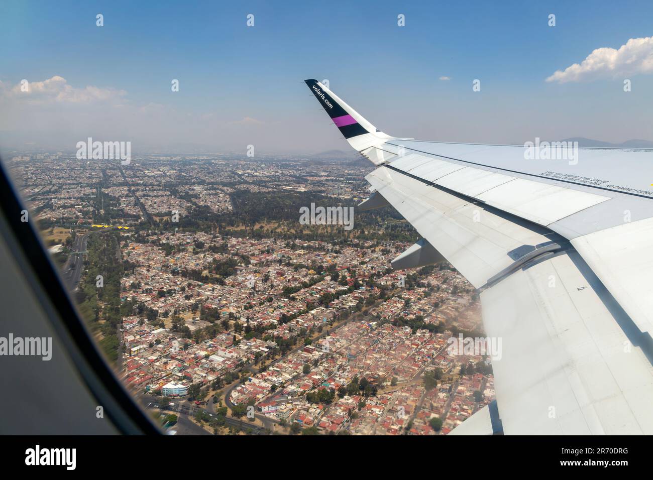 Oblique angle aerial view through plane window over Mexico City, Mexico ...