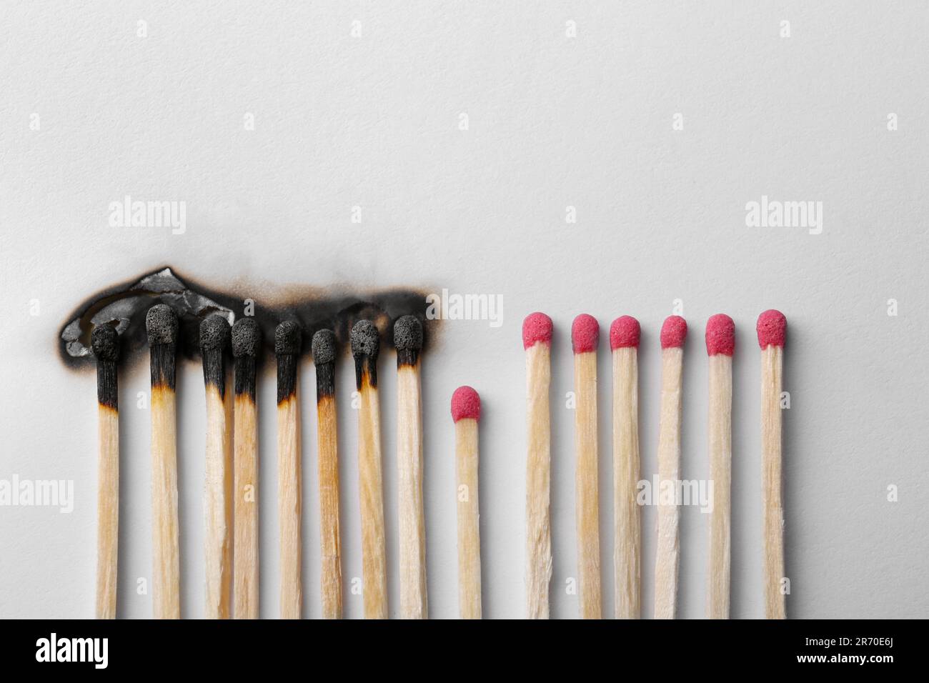 Burnt and whole matches on white background, flat lay. Space for text ...