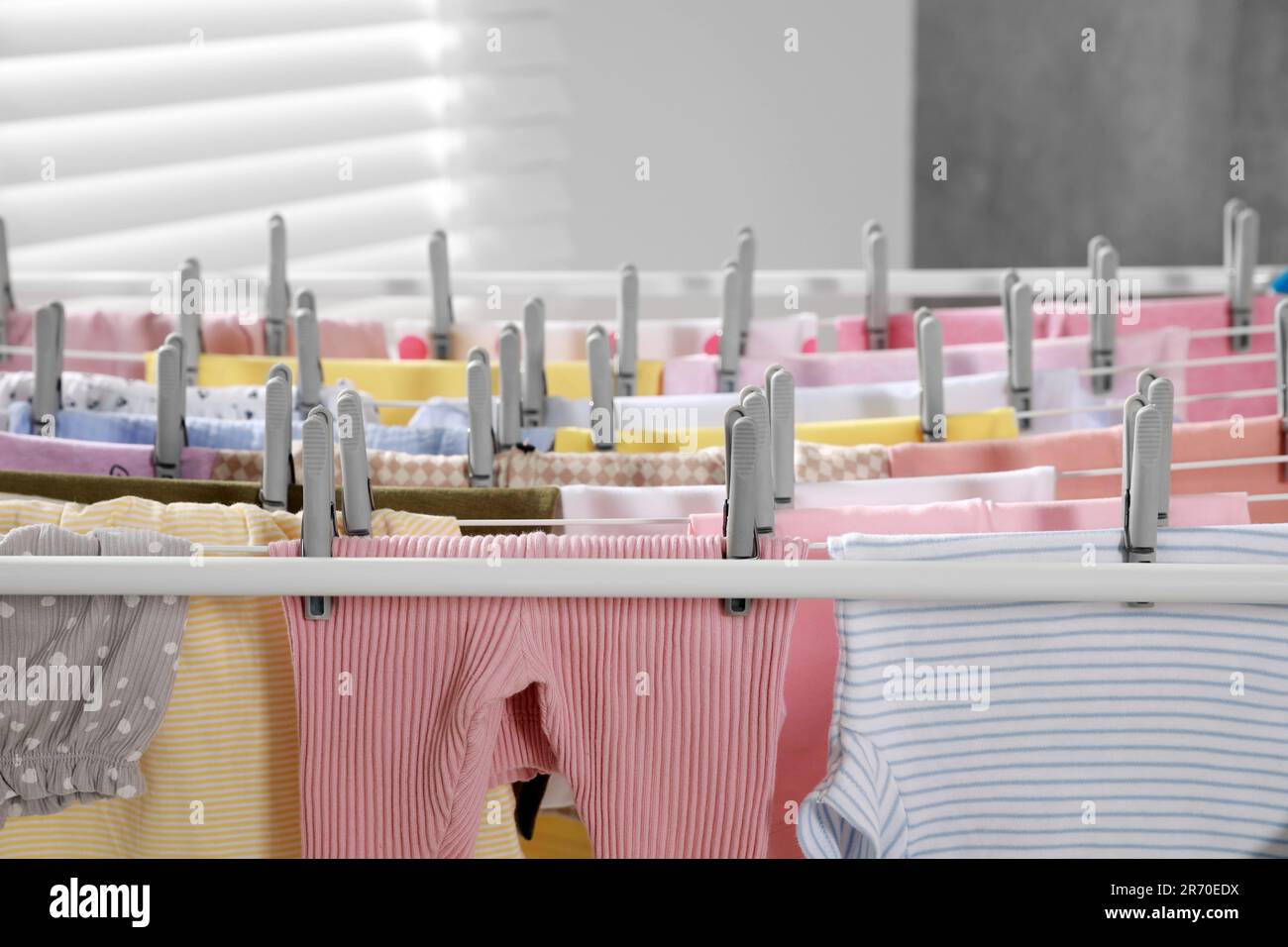 Clean laundry hanging on drying rack indoors Stock Photo - Alamy