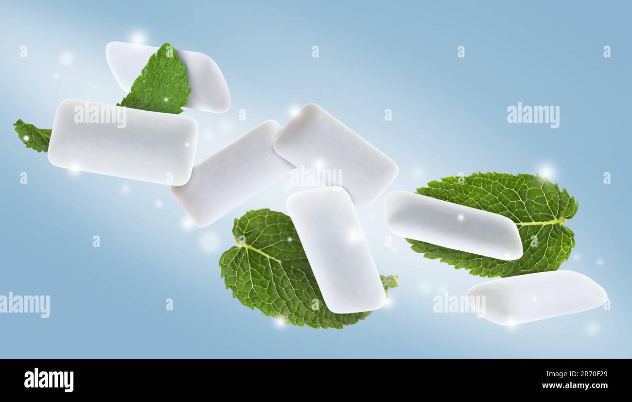 Fresh mint leaves and chewing gum pads falling around lights on light ...