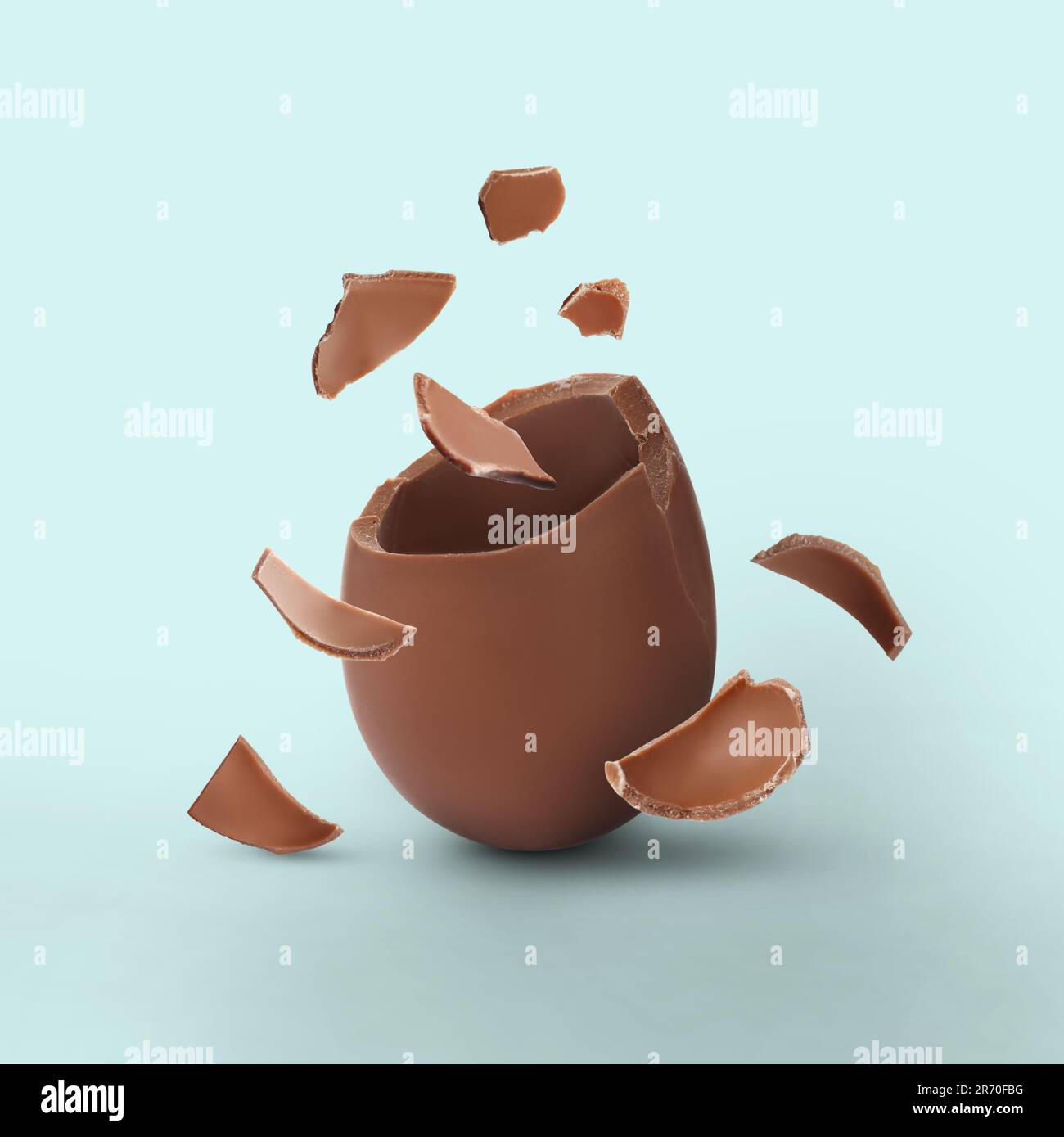 Exploded milk chocolate egg on dusty light blue background Stock Photo ...