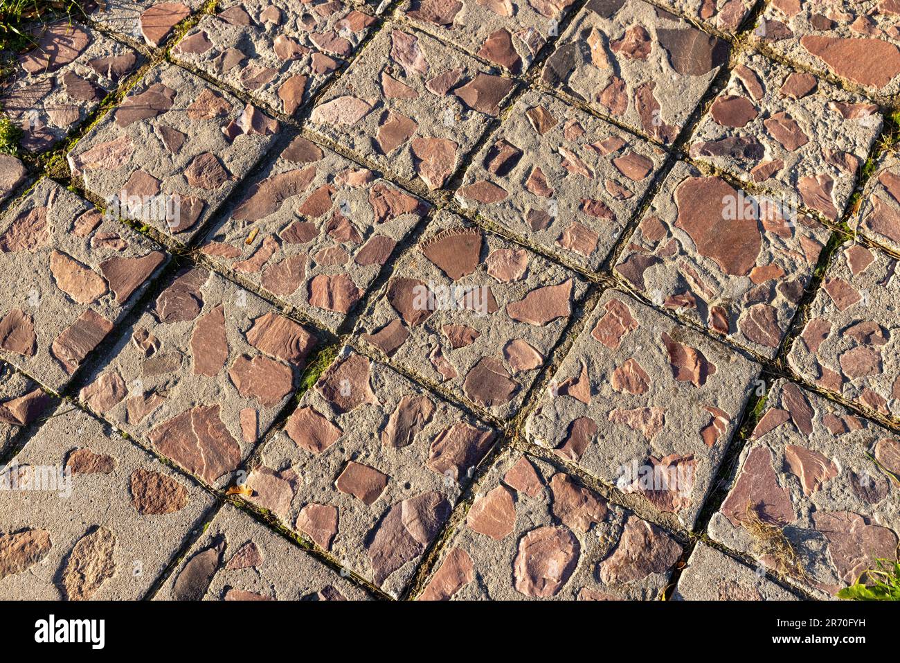 Part of the pedestrian road is made of red stones connected by cement ...