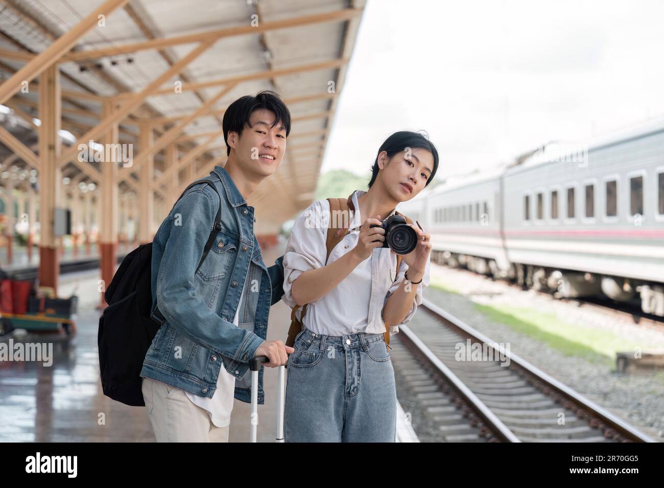 Beautiful couple at railway station waiting for the train. Young woman ...