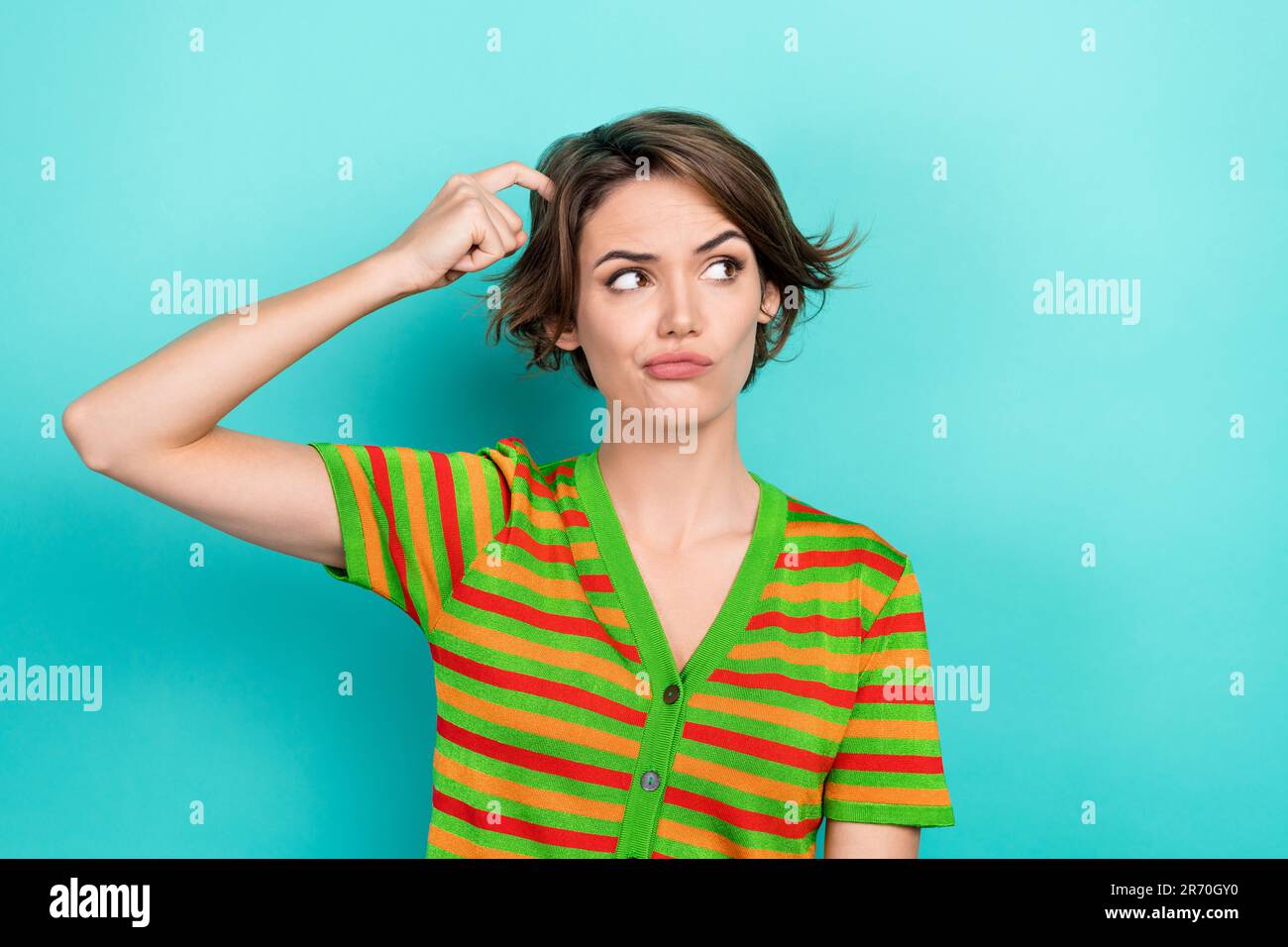 Photo of doubtful unsure lady wear striped cardigan finger head looking ...