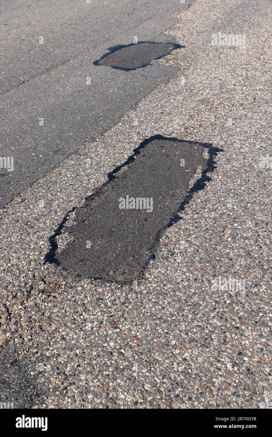 The repaired part of an asphalt road with patches, repair and ...
