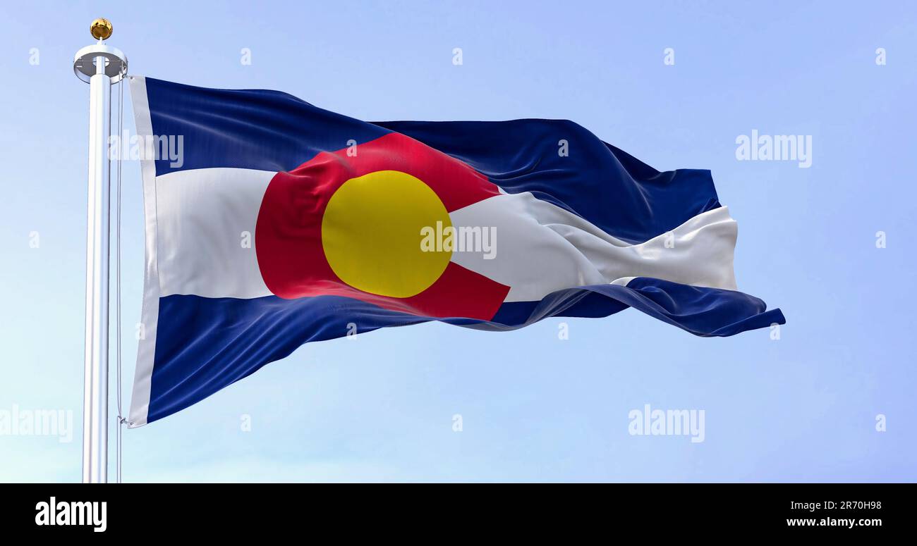Colorado state flag waving in the wind on a clear day. Three blue ...