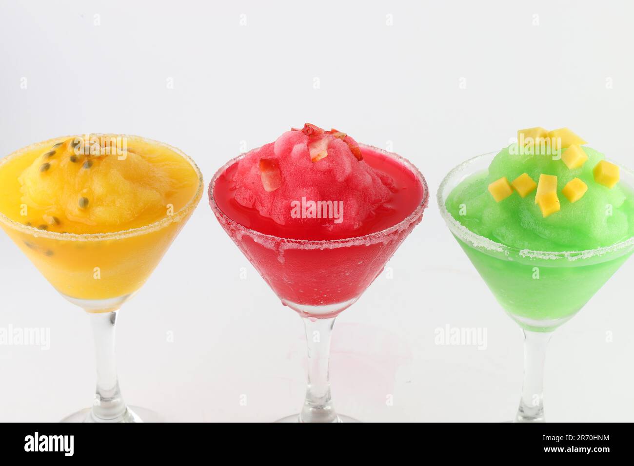 Three delightful martini glasses filled with different colored cocktails, all frosted with ...