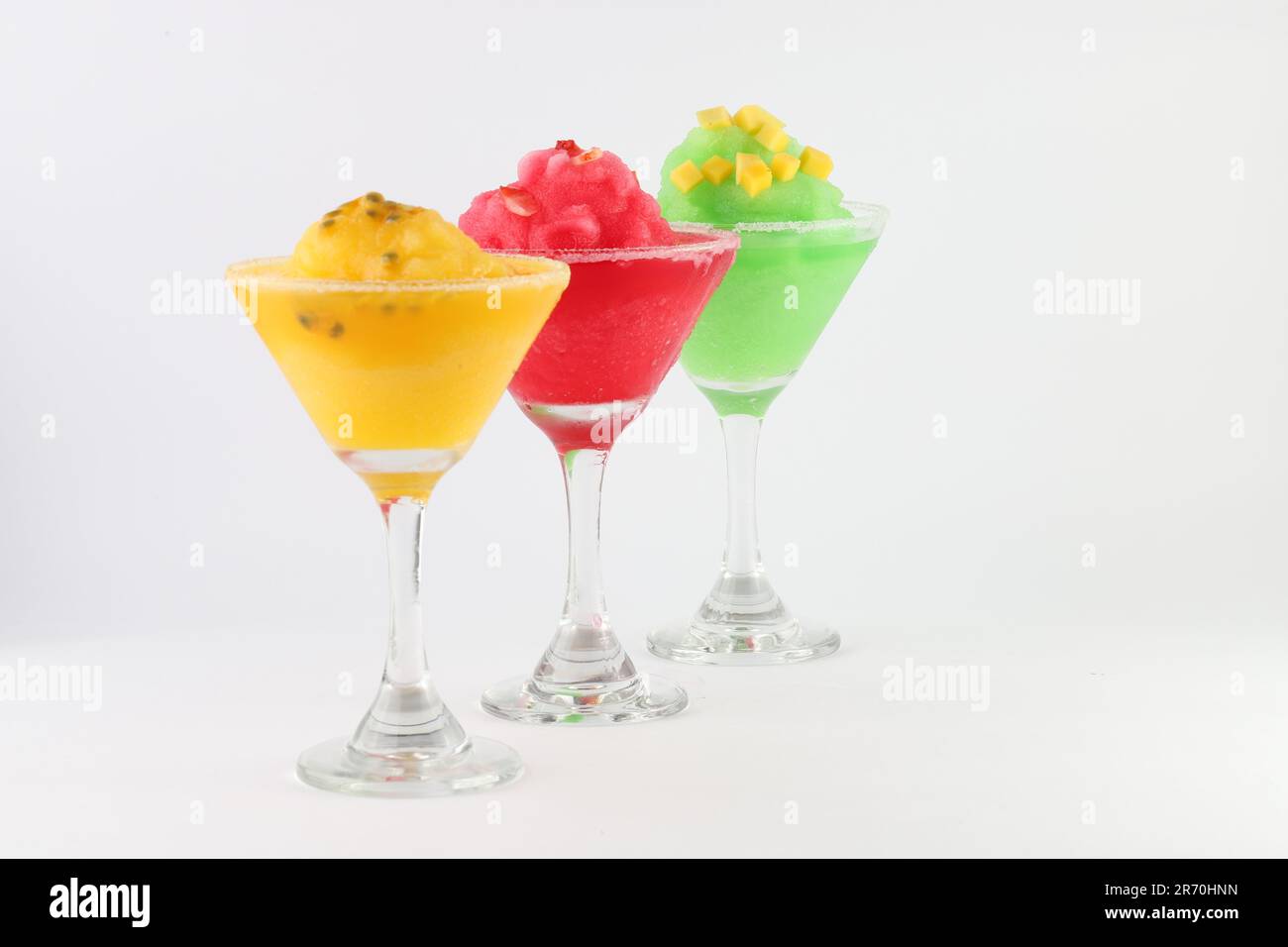 Three delightful martini glasses filled with different colored cocktails, all frosted with ...