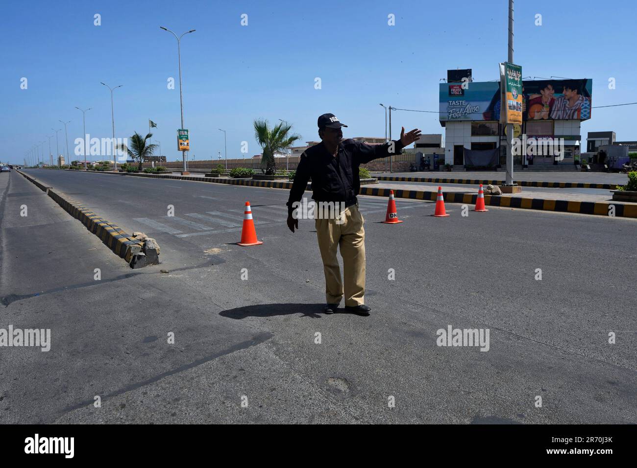 A police officer gestures to commuters for alternate route at a ...