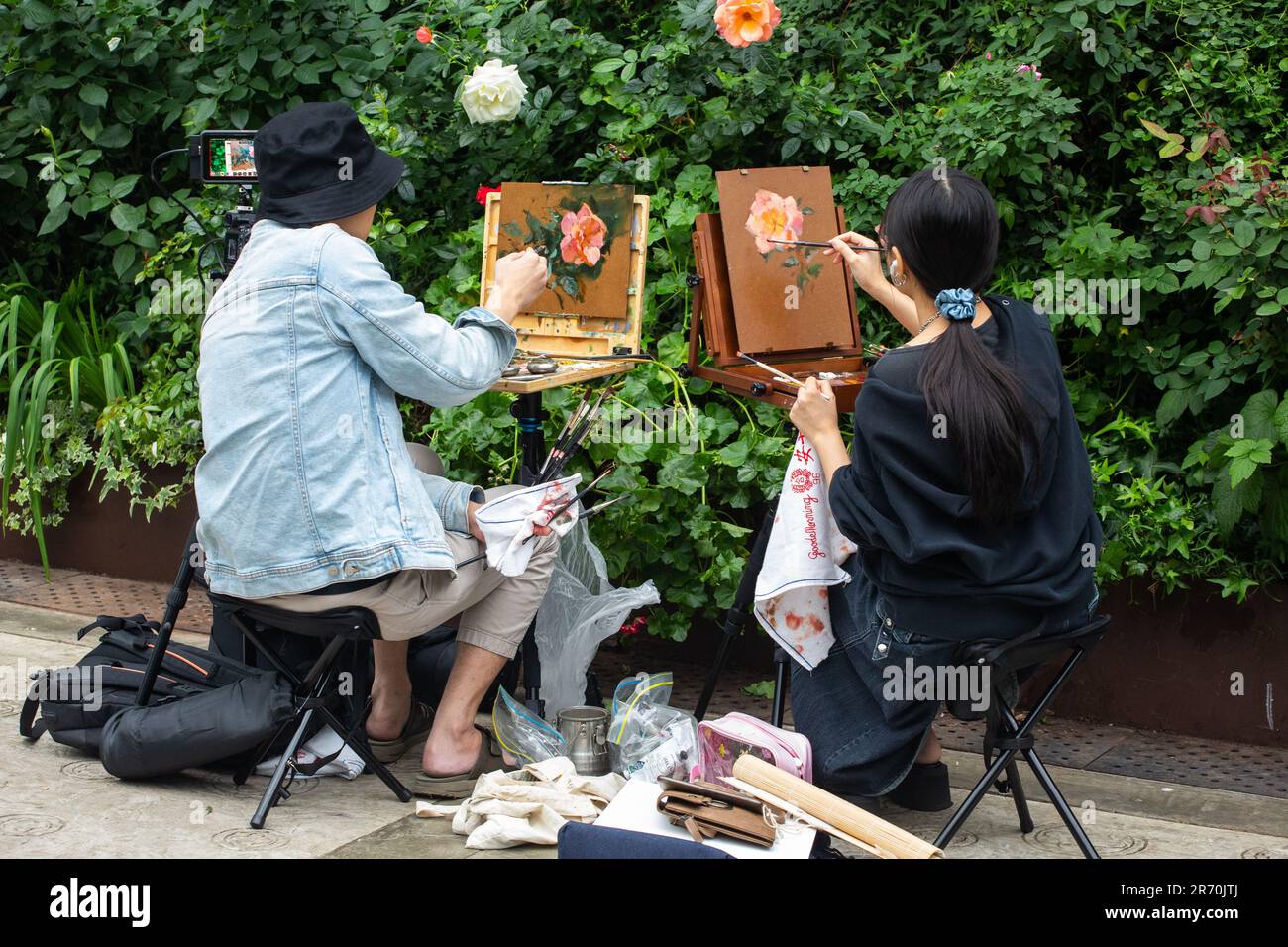 Artistic painter, a man and woman painting in an indoor plant setting ...