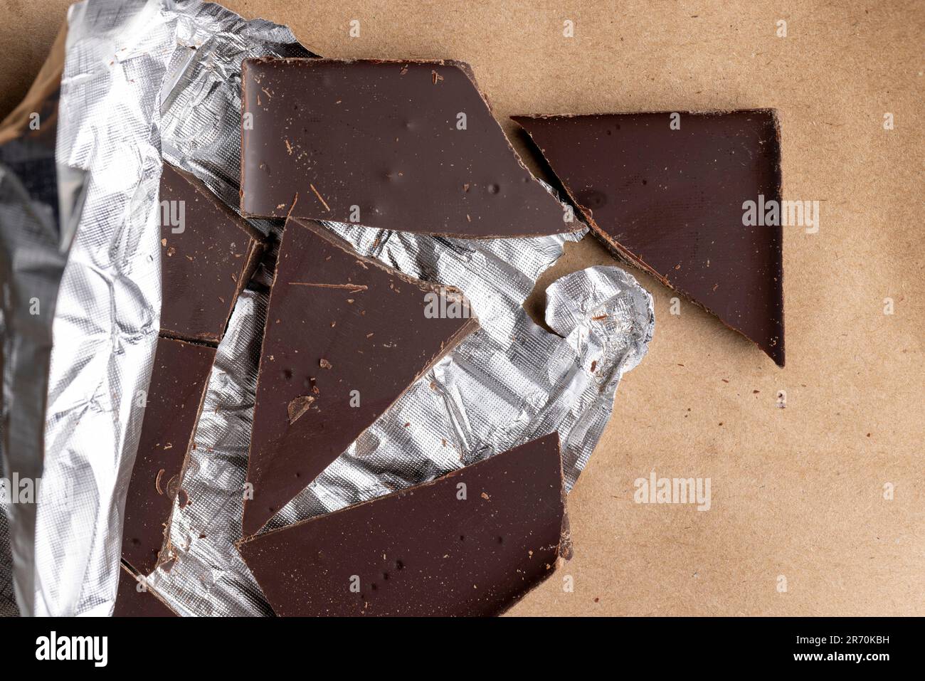 A broken chocolate bar in a paper and foil package, a sweet chocolate ...