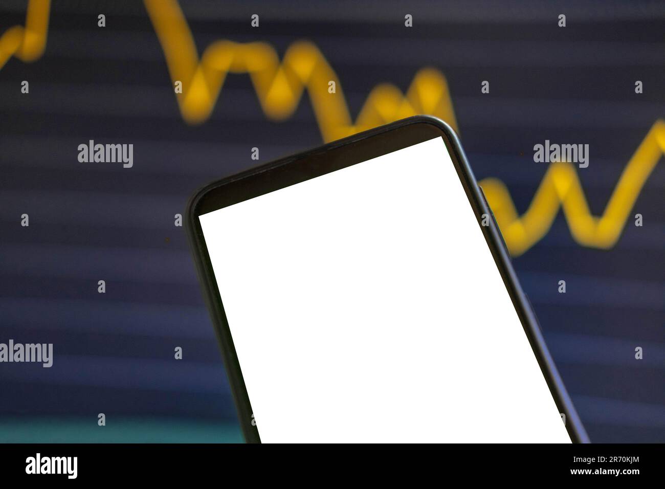 Black phone with blank mockup screen on rising stock graph. Closeup ...