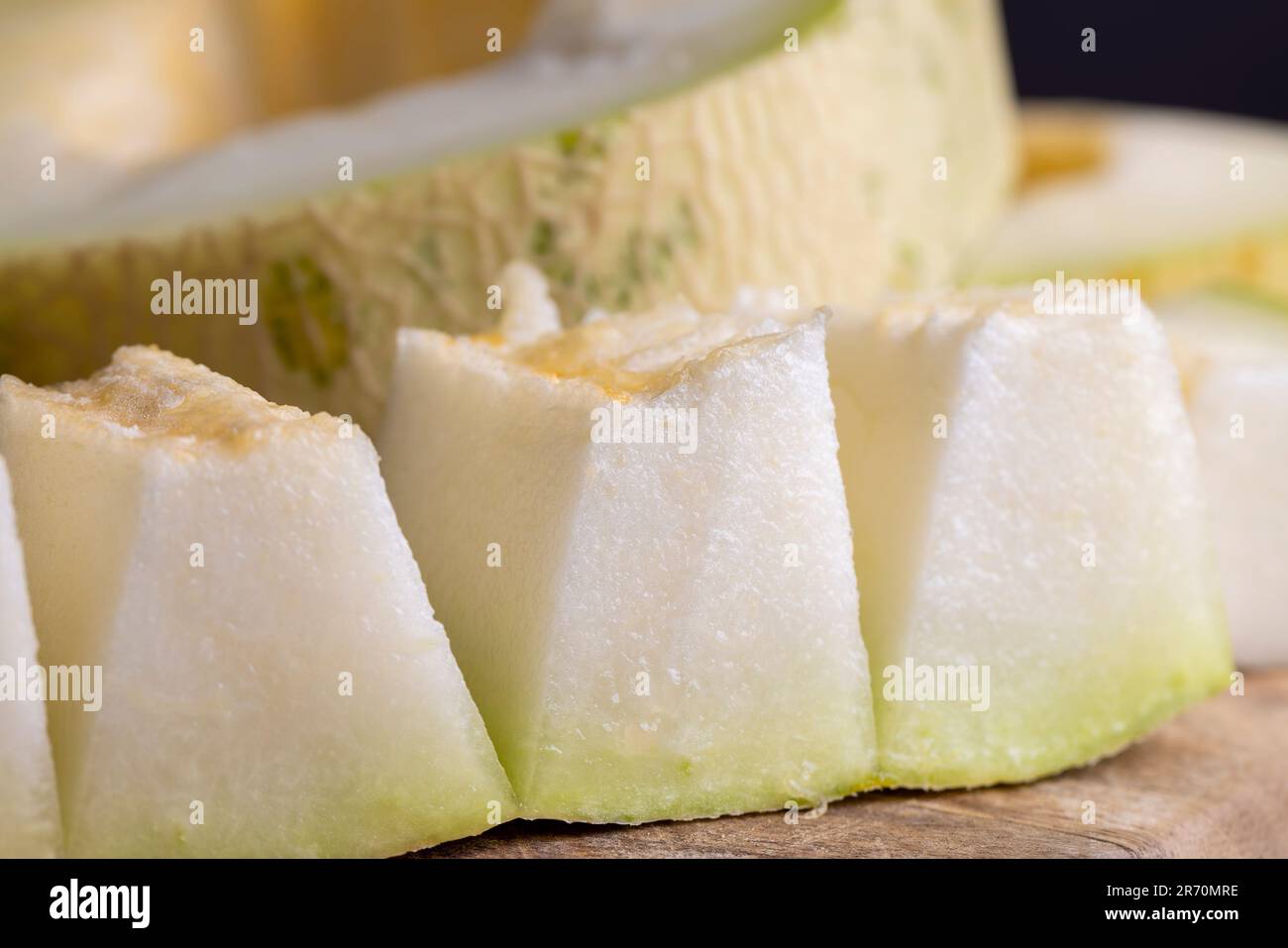 Cut into pieces ripe yellow melon with sweet pulp, cut melon on kitchen ...