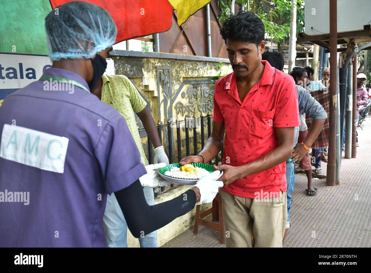 People receive food from a social worker on 'World Food Safety Day ...