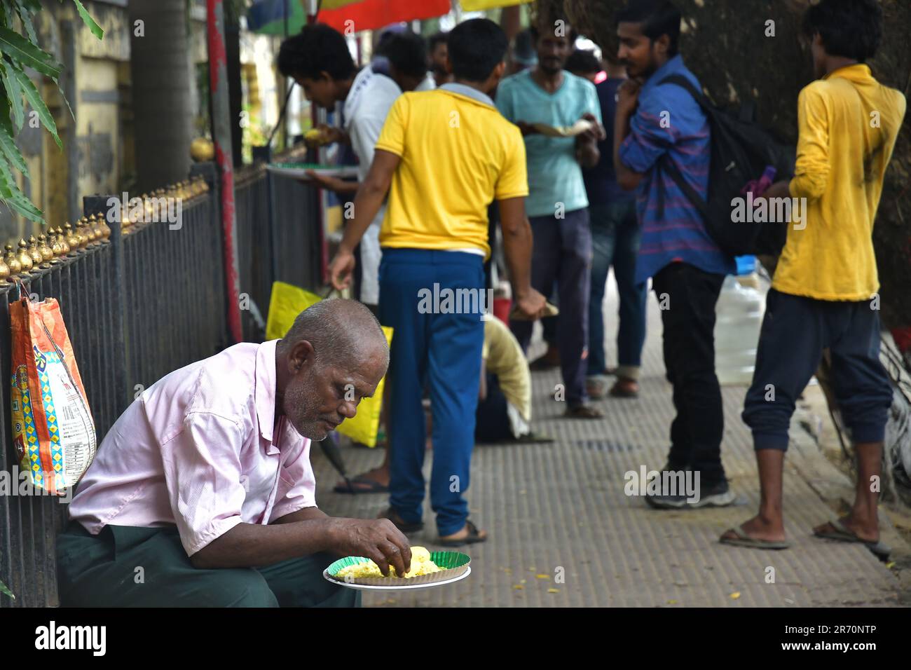 People eat food distributed by a social worker on 'World Food Safety ...