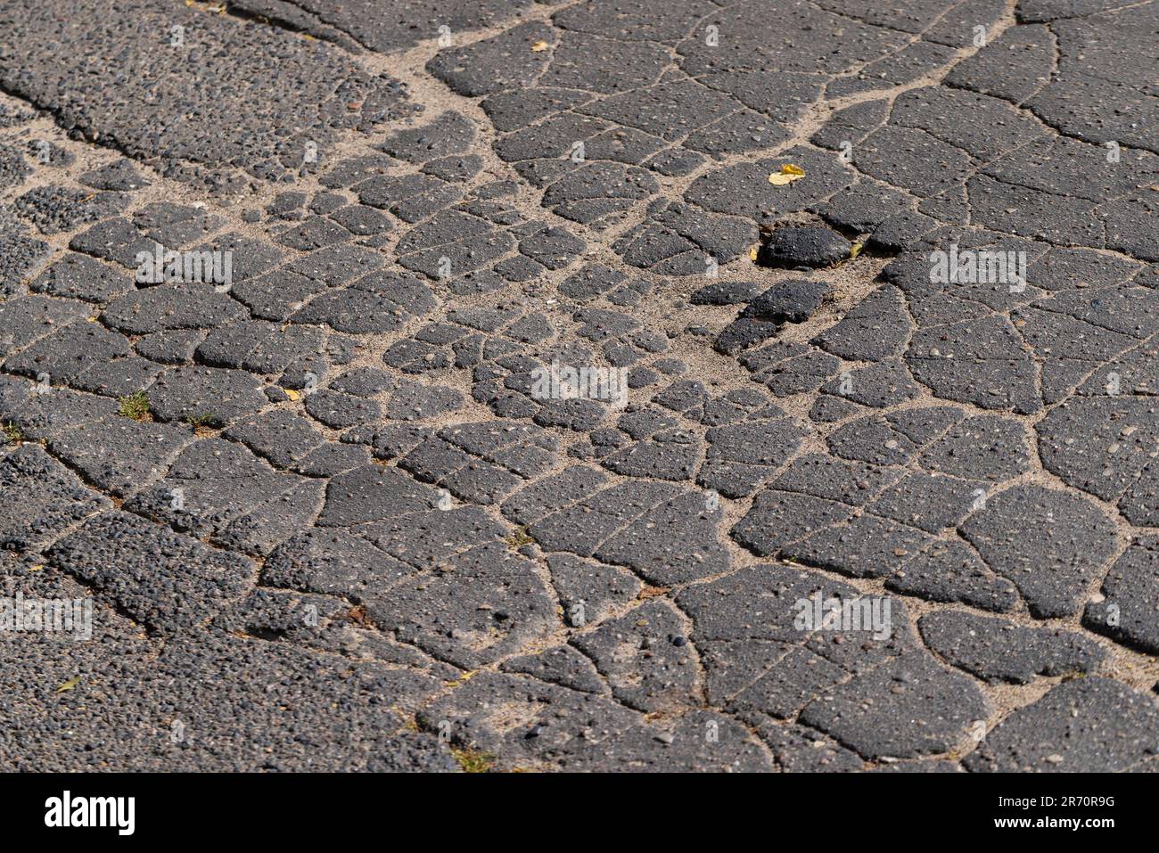 A damaged road dangerous for traffic, pits and cracks on the asphalt of ...