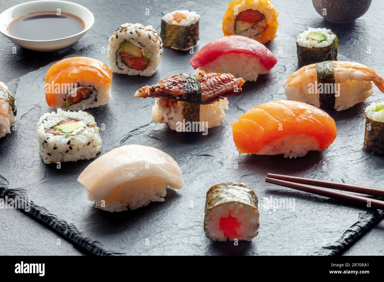 Sushi with chopsticks. Rolls, maki, nigiri on a black background ...