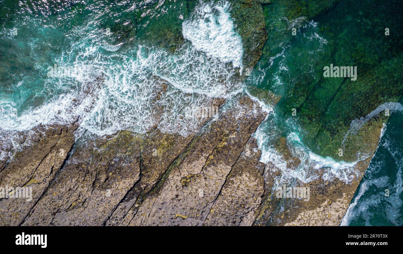 Connacht 2022. Aerial view of water breaking on the rock made coast of ...