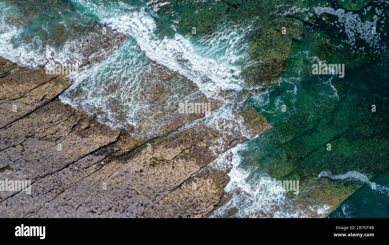 Connacht 2022. Aerial view of water breaking on the rock made coast of ...