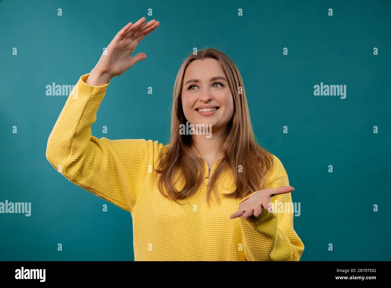 Young woman showing big invisible abstract subject, object sizes. Large ...