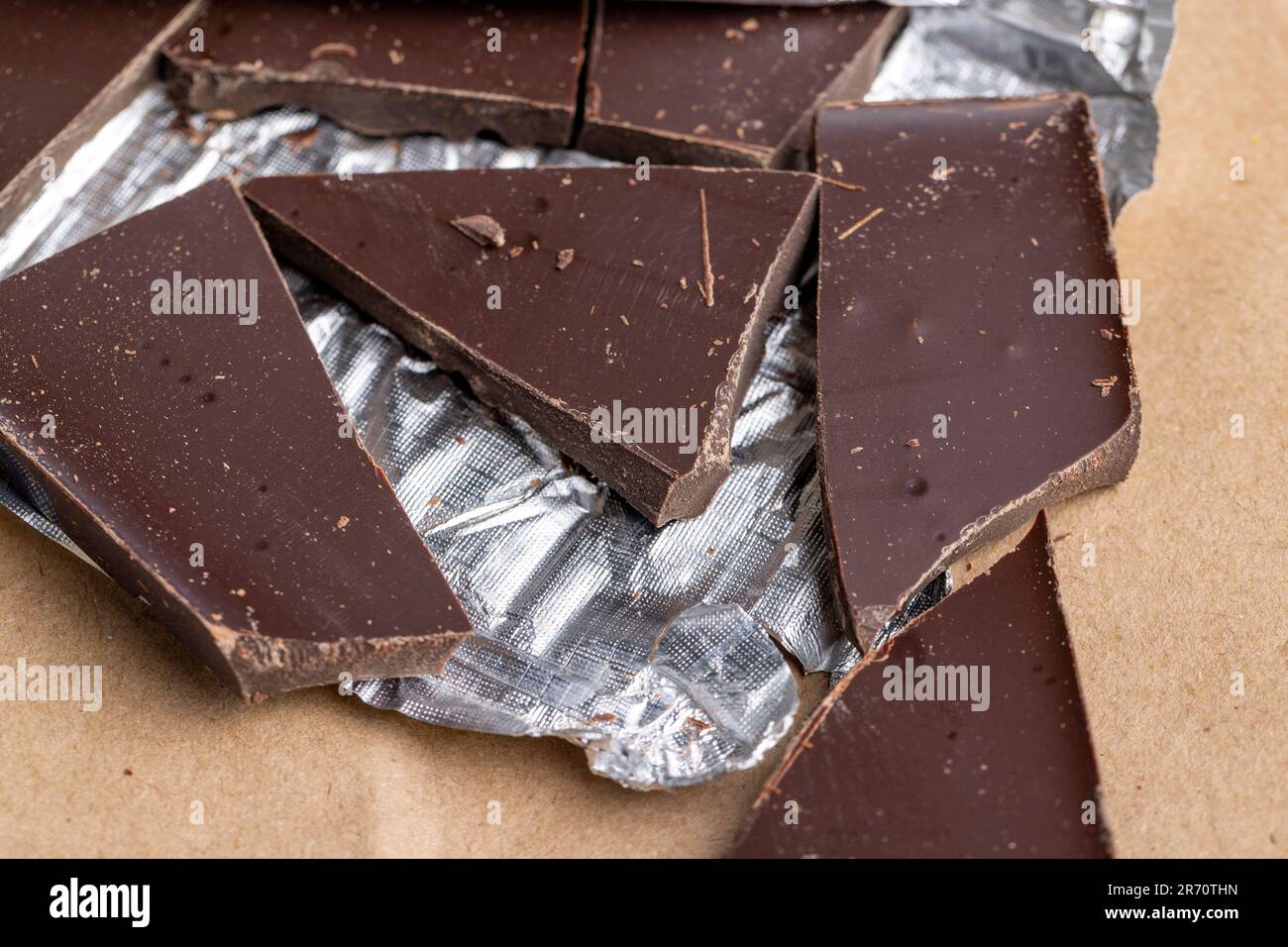 A broken chocolate bar in a paper and foil package, a sweet chocolate ...