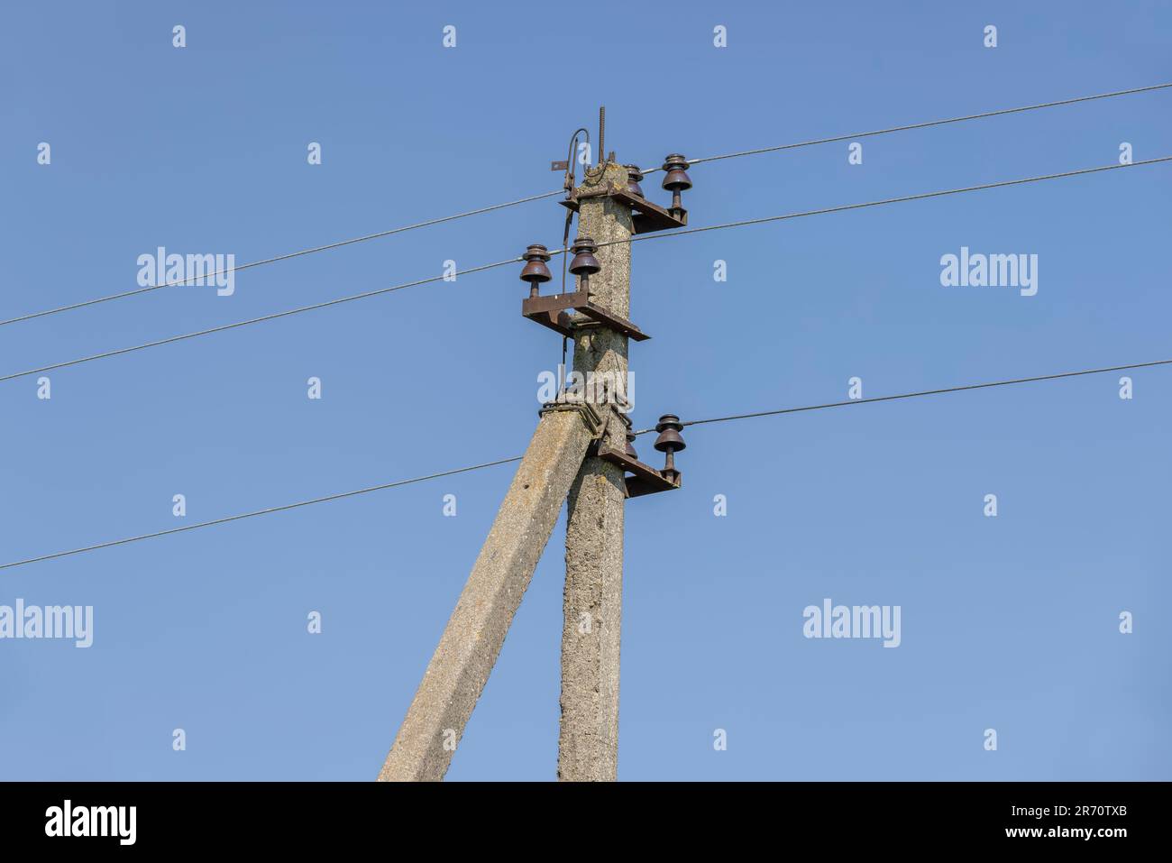 High voltage power lines mounted on concrete poles, metal wires on ...