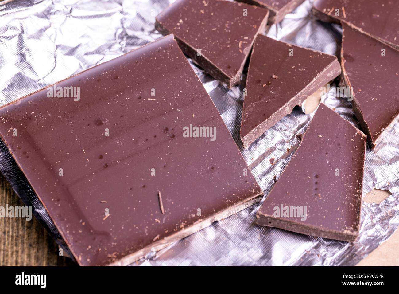 A broken chocolate bar in a paper and foil package, a sweet chocolate ...