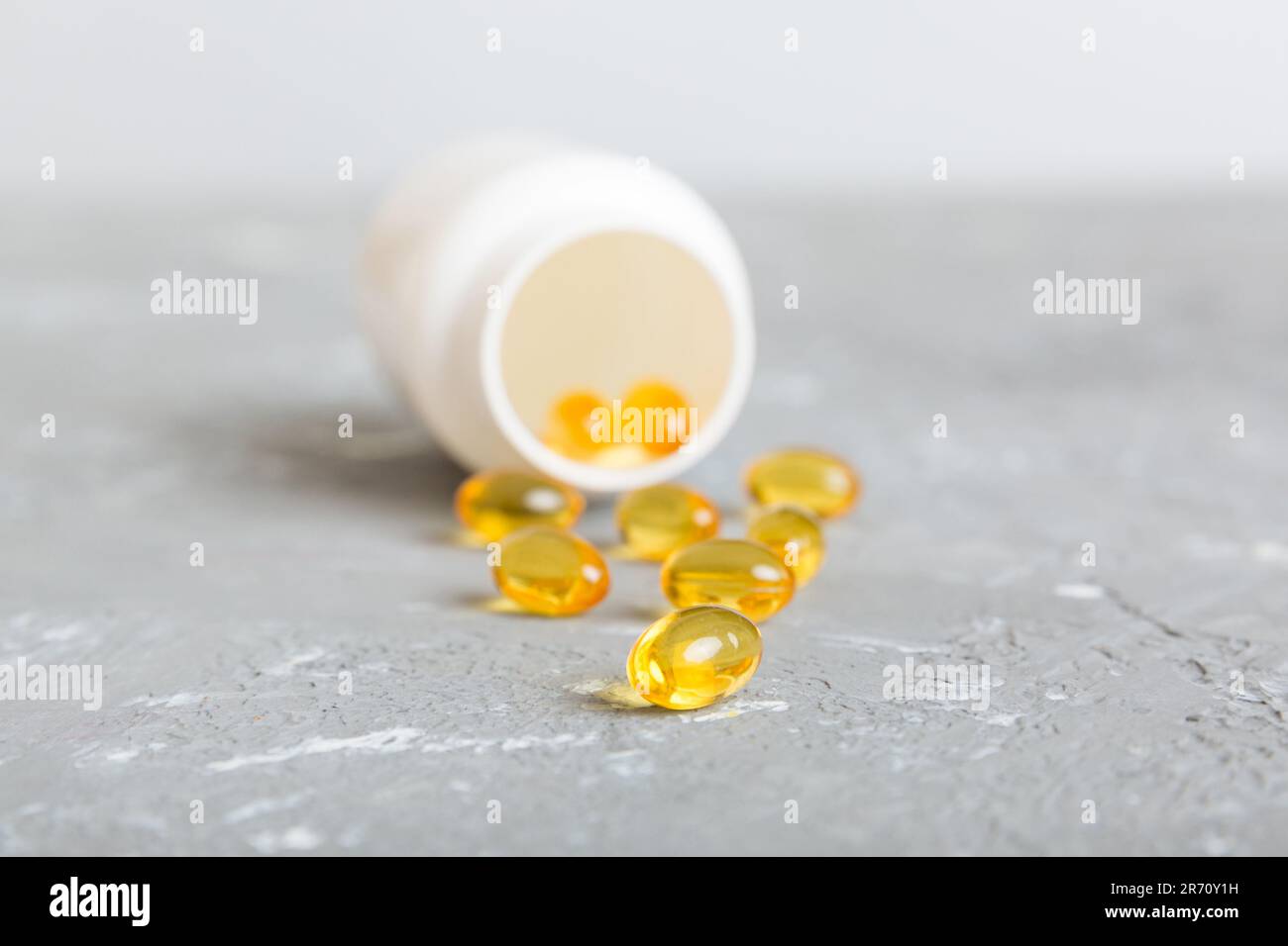 Soft gels pills with Omega-3 oil spilling out of pill bottle close-up ...