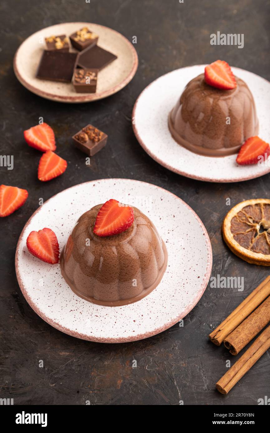 Chocolate jelly with strawberry on black concrete background. side view ...