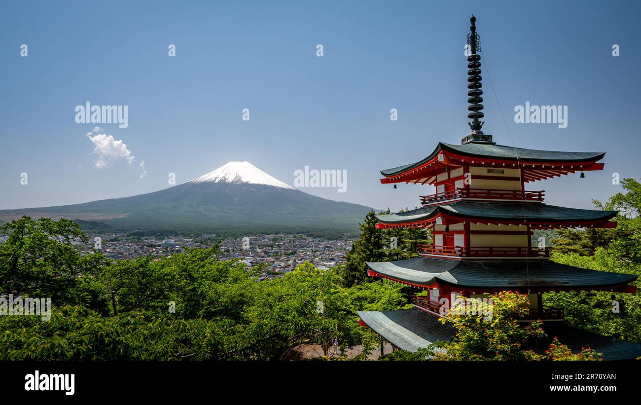 A traditional Japanese pagoda stands atop a hill, overlooking the ...