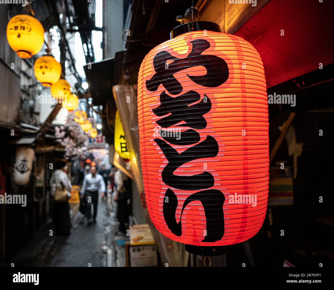 An array of colorful paper lanterns decorate a narrow alley in a busy ...