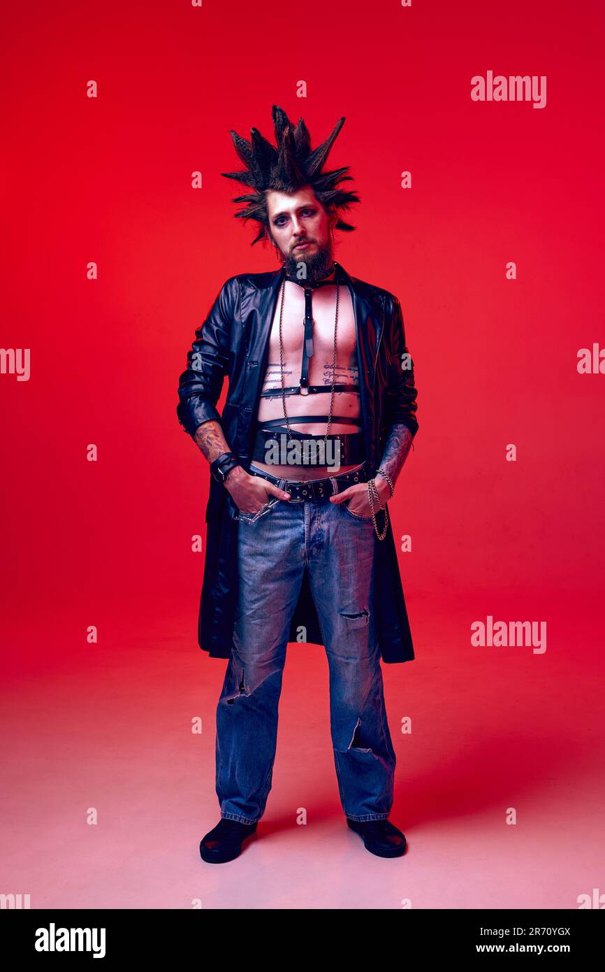Full-length portrait of young guy in image of punk with extraordinary ...