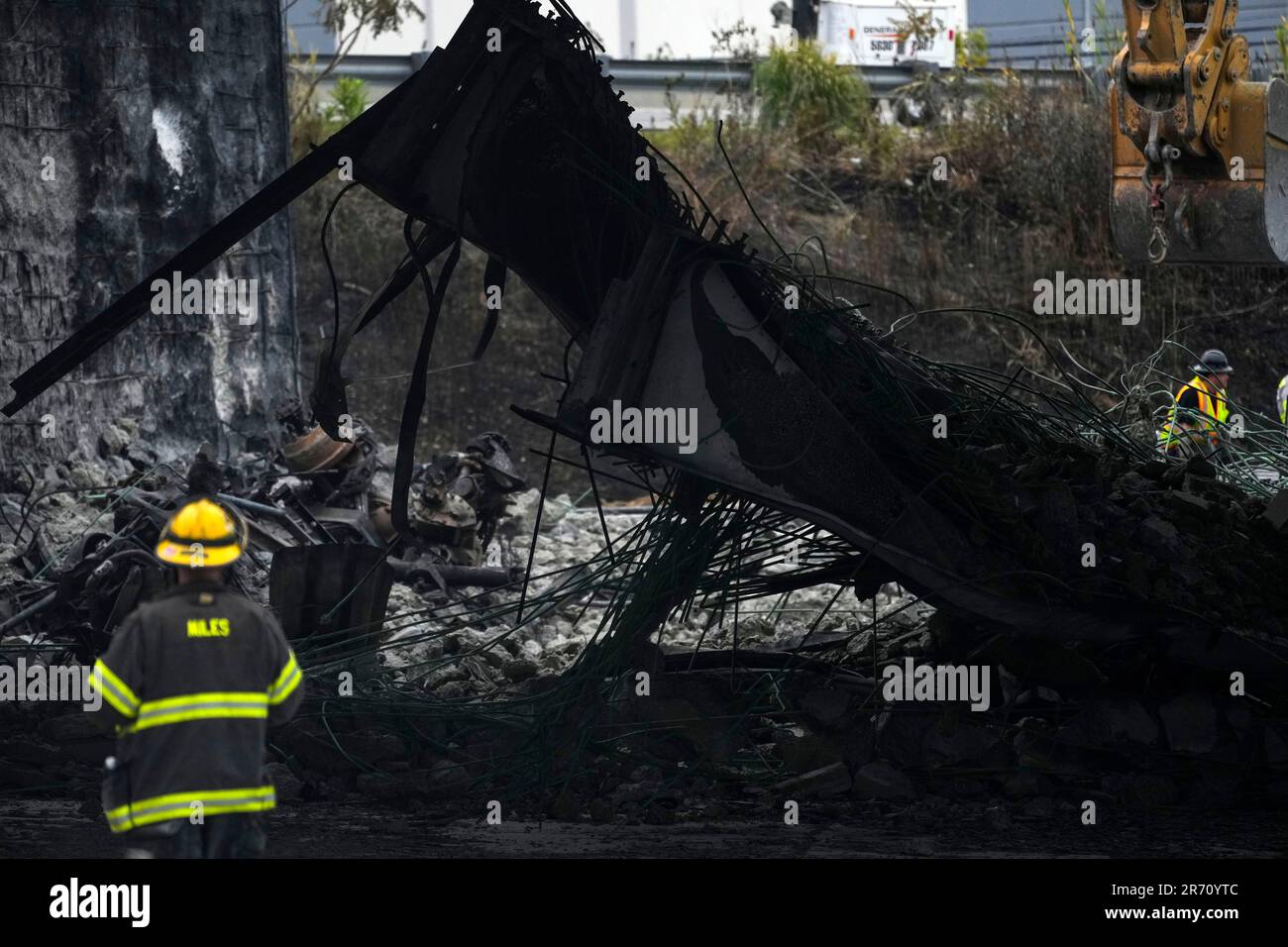 A firefighter views the aftermath of an elevated section of Interstate ...