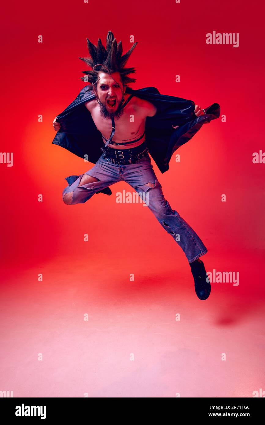 Full-length portrait of young punk in extraordinary clothes, hairstyle ...