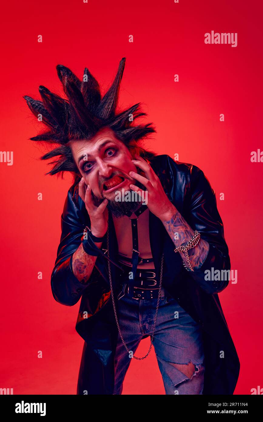 Crazy face. Portrait of expressive young man, punk posing in makeup and ...