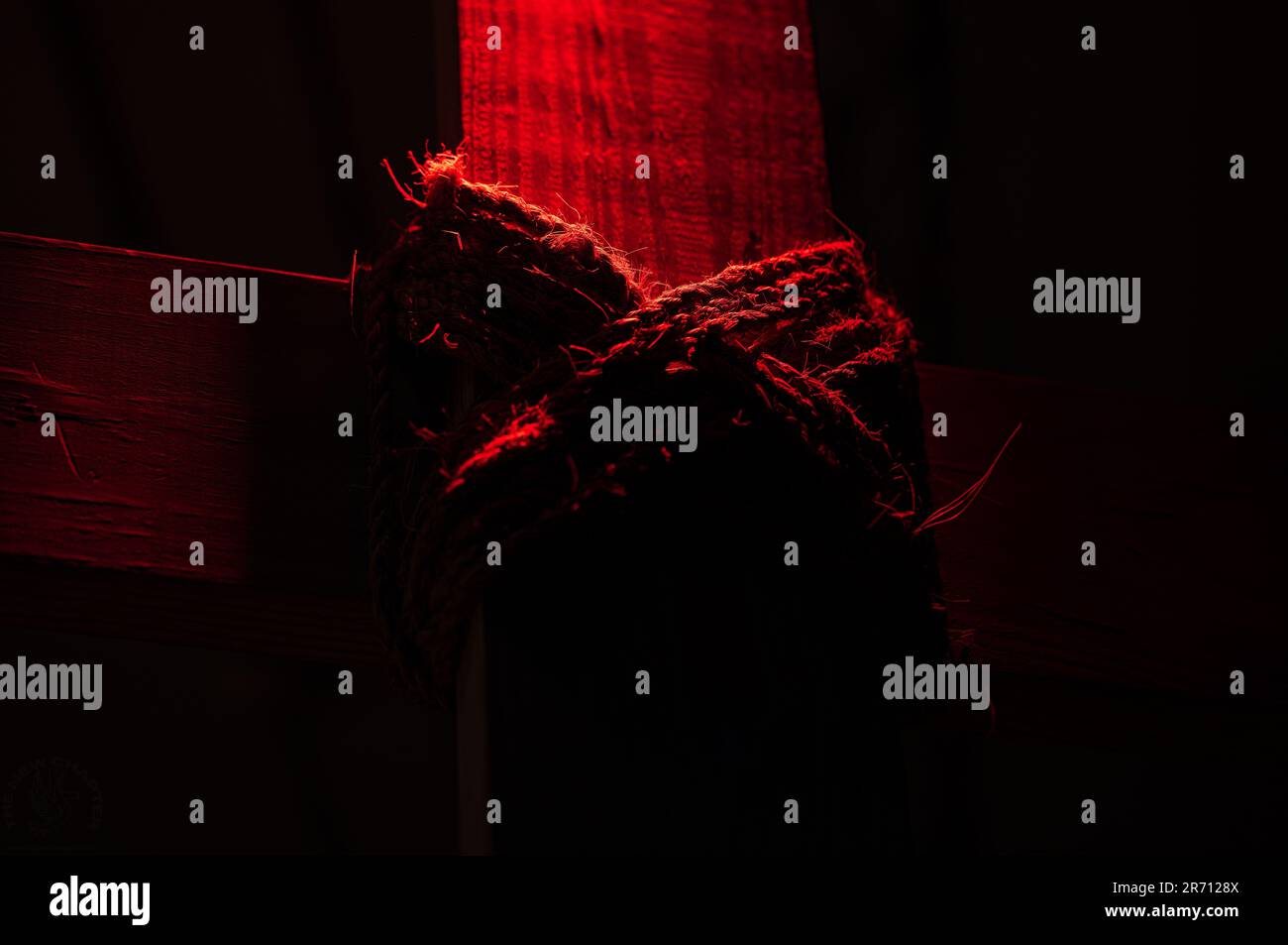 An illuminated Christian cross in a dimly lit room, illuminated by a ...