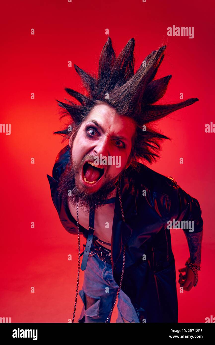 Crazy face. Portrait of expressive young man, punk posing in makeup and ...