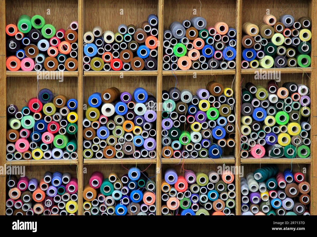A close up of an array of colorful spools of thread in different sizes ...