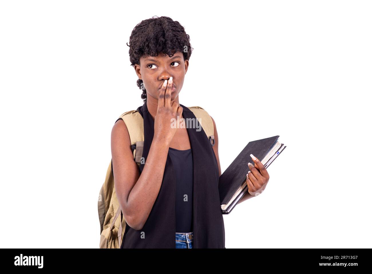 young student girl wearing a backpack holding fingers on her lips Stock ...