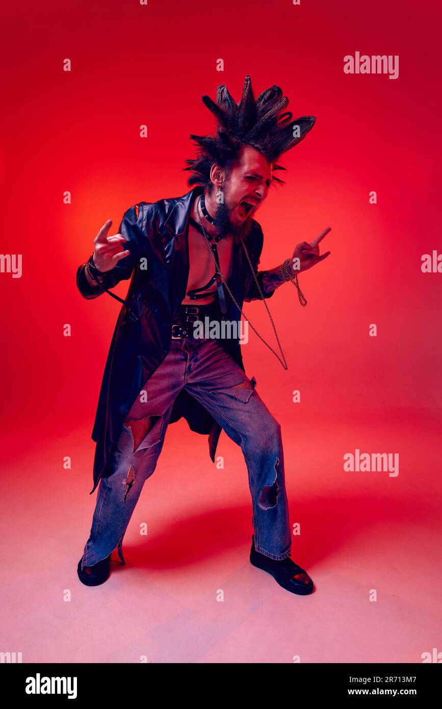 Full-length portrait of young punk in extraordinary clothes, hairstyle ...