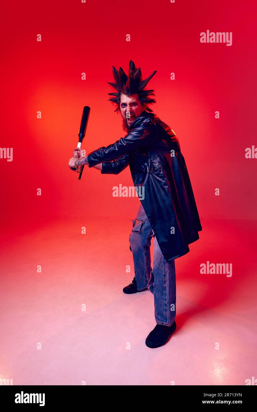 Expressive young man, punk with weird hairstyle and makeup ...