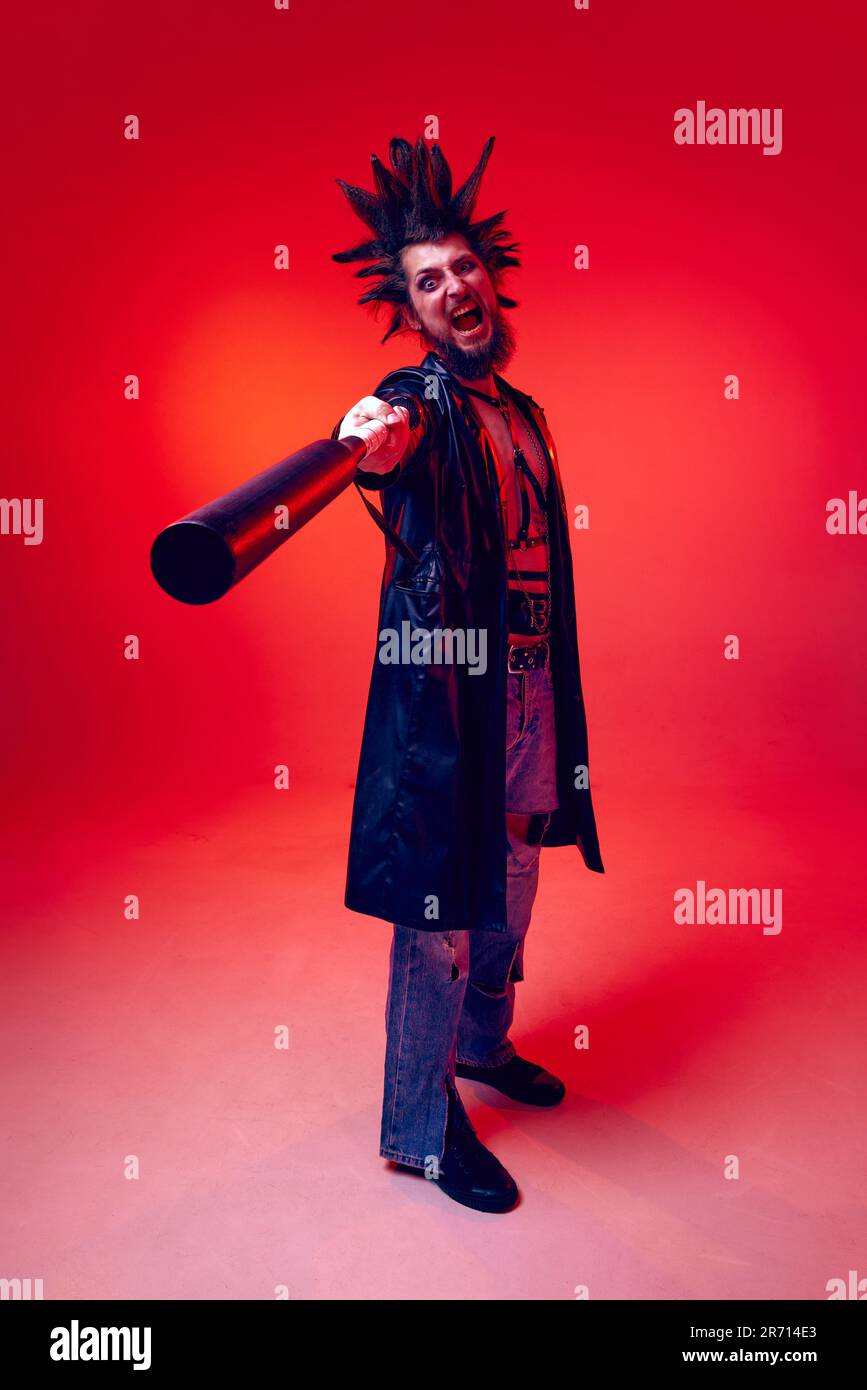 Expressive young man, punk with weird hairstyle and makeup ...