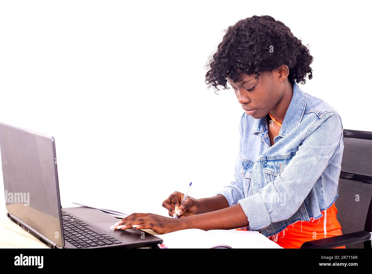portrait of a young student girl taking notes in the notebook using a ...