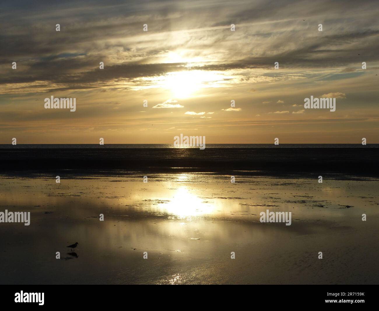 A stunning sunset with vivid colors casts a reflection over a tranquil ...