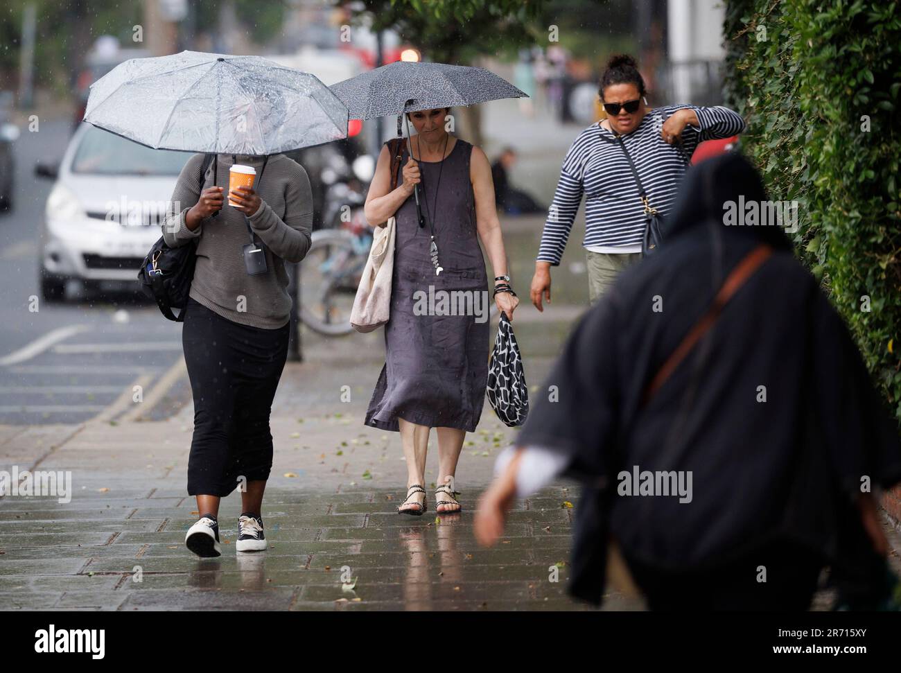 London, UK. 12th June, 2023. Members of the public get caught in a ...