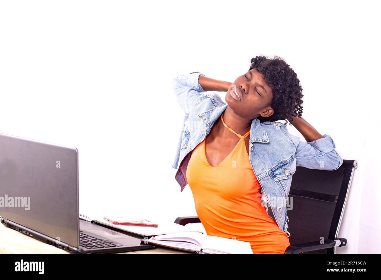 young tired student girl sitting on the table facing the computer and ...