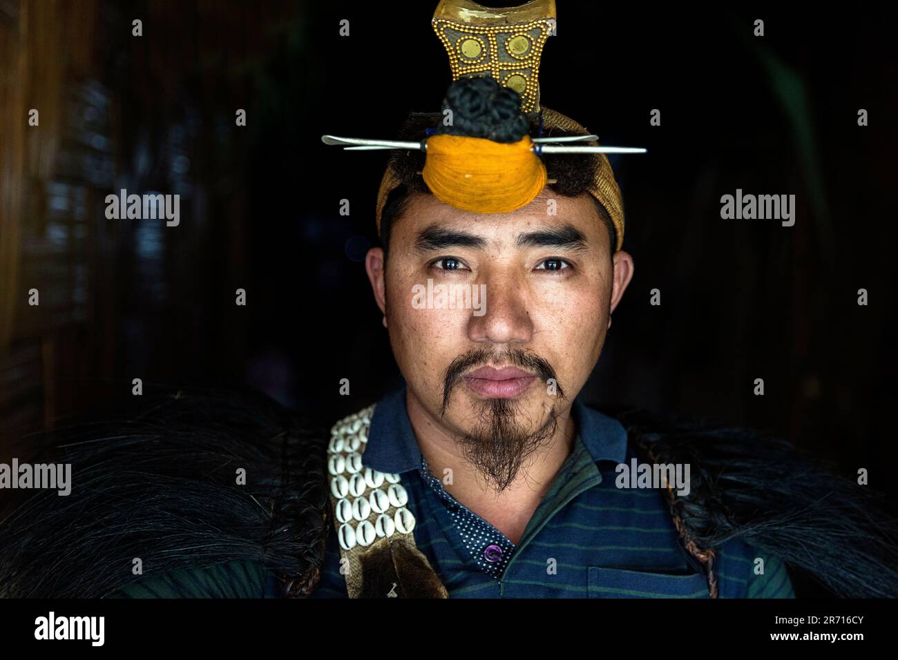 Portrait of a young Nishi man wearing traditional head-dress including ...