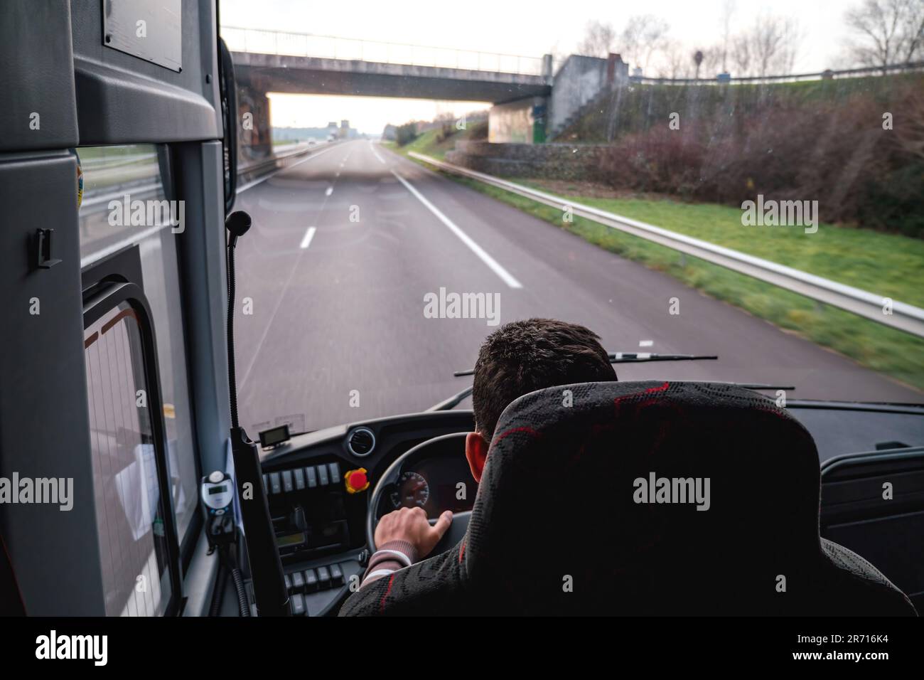A lone driver commutes on the German autobahn in a coach bus as an ...