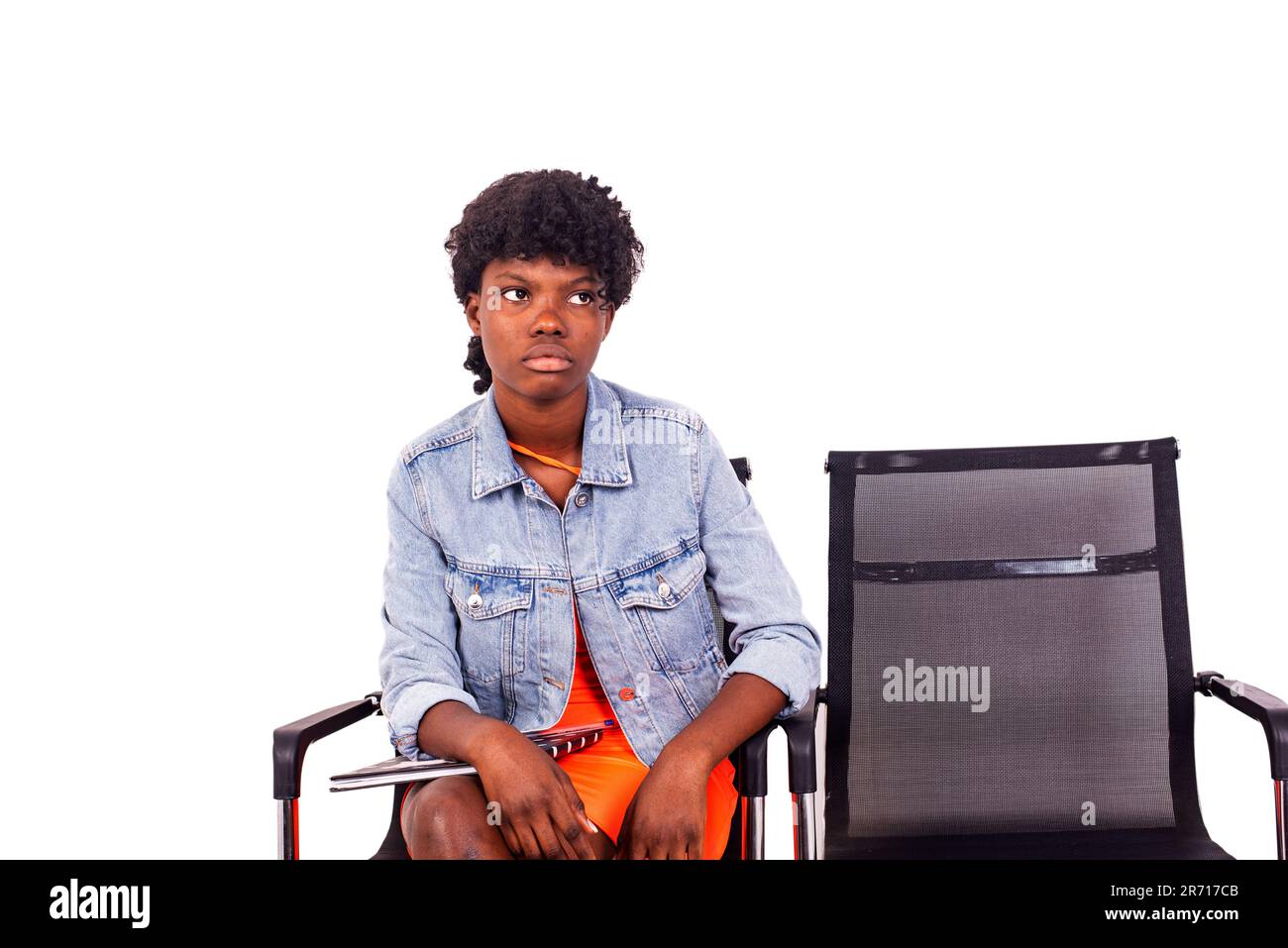 portrait of an impatient young girl sitting on a chair waiting for a ...